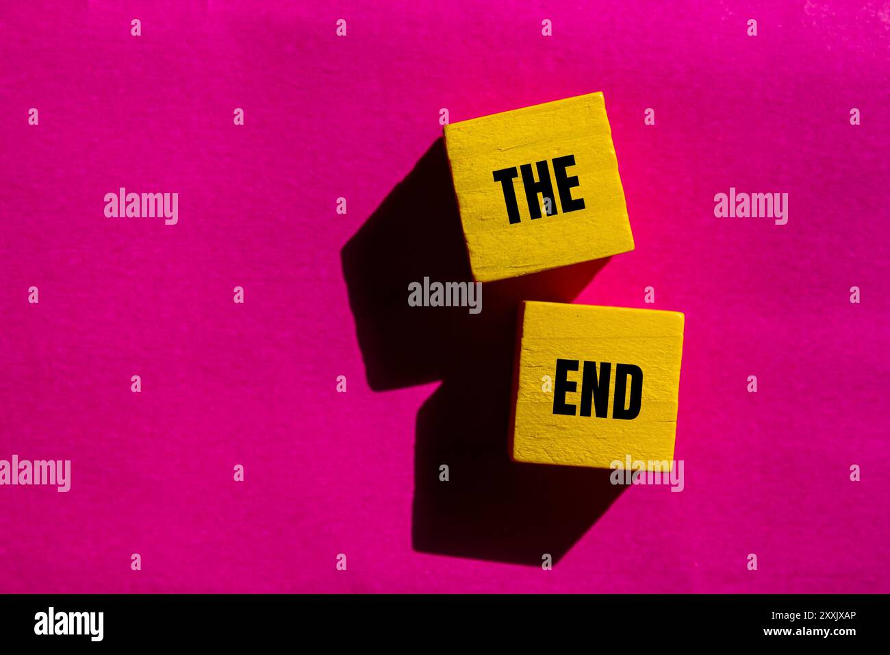 The end message written on yellow wooden cubes with pink background ...
