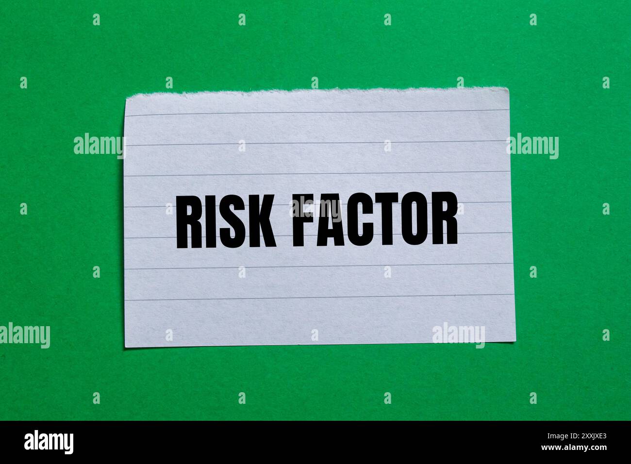 Risk factor message written on ripped torn paper piece with green ...