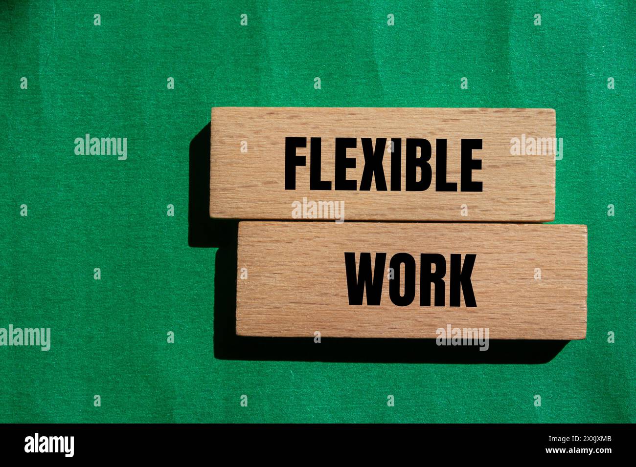 Flexible work message written on wooden blocks with green background ...