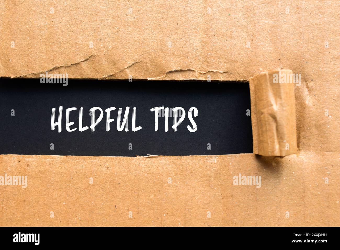 Helpful tips message written on ripped torn cardboard paper with black ...