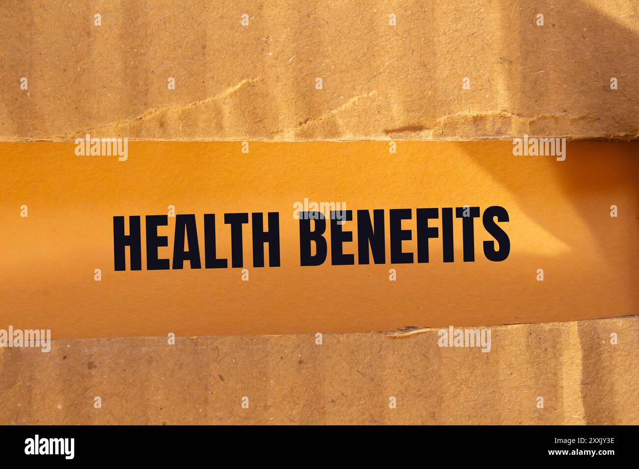 Health benefits message written on ripped torn cardboard paper with orange background ...
