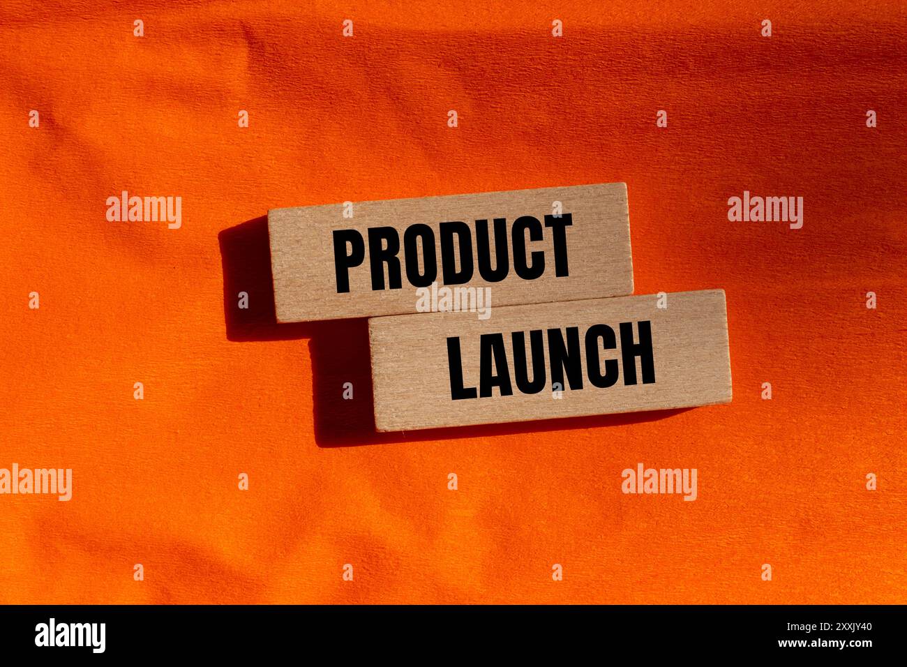 Product launch message written on wooden blocks with orange background ...