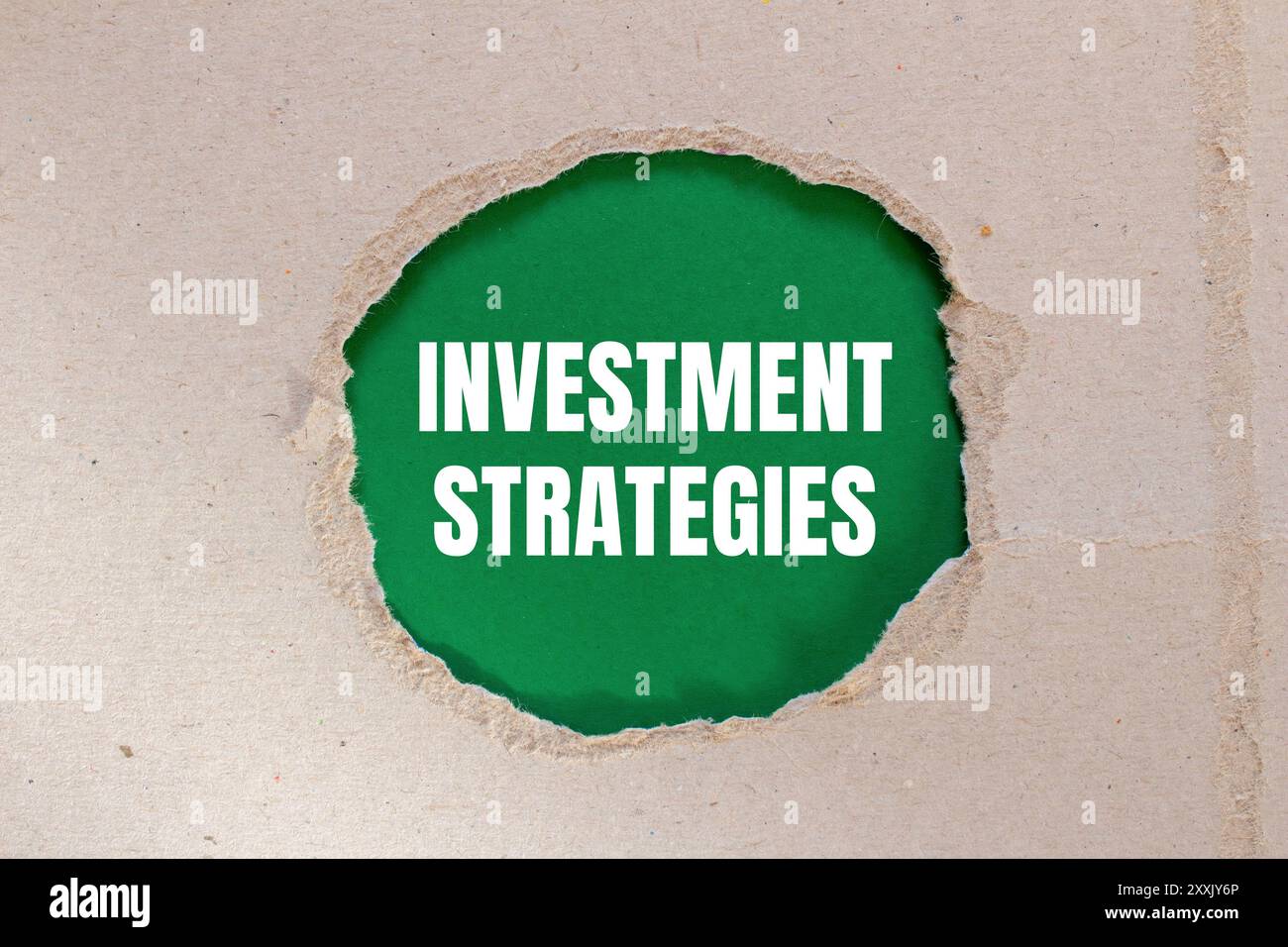 Investment strategies message written on ripped torn paper with green ...