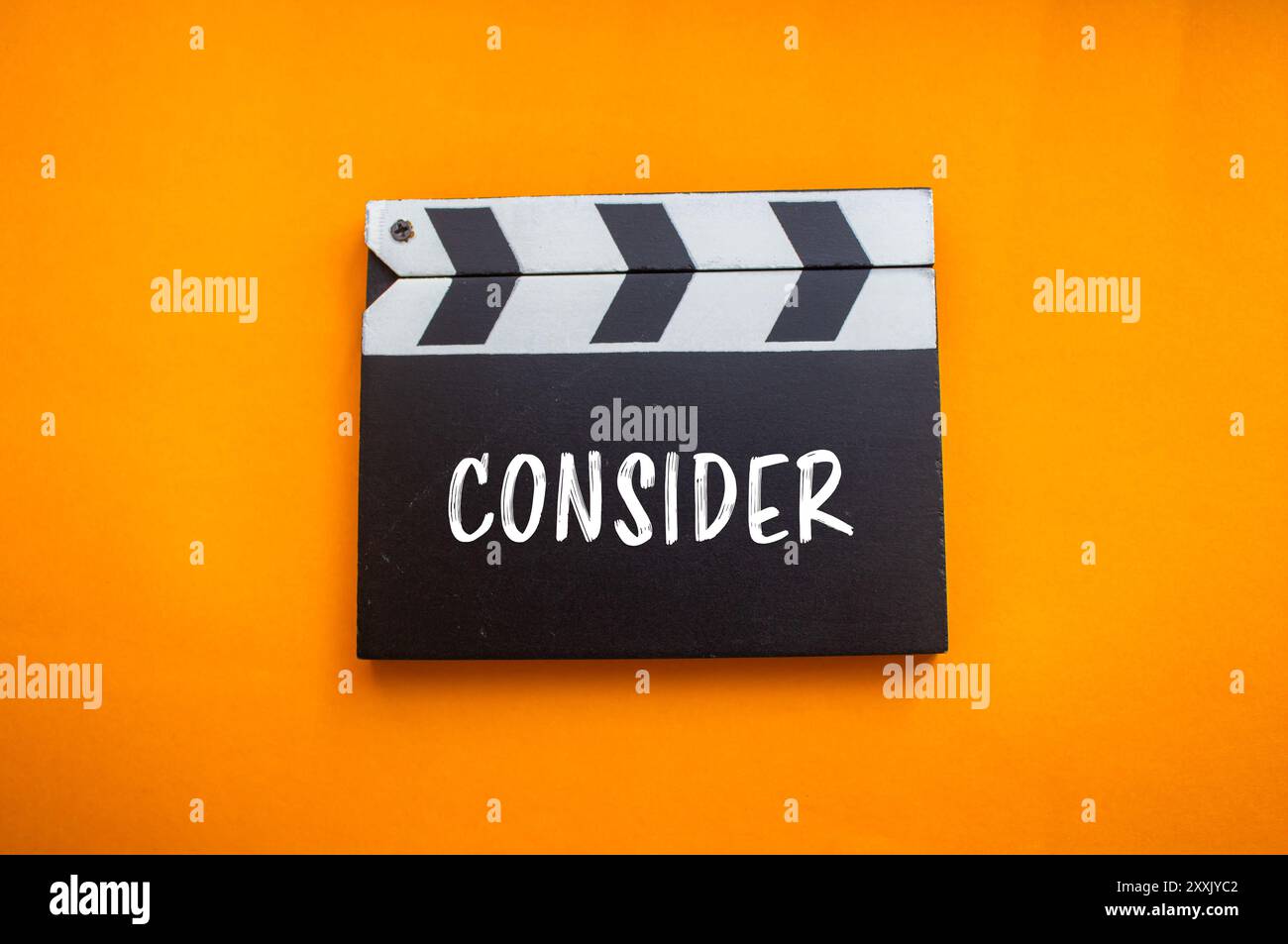 Consider message written on movie clapper board with orange background ...
