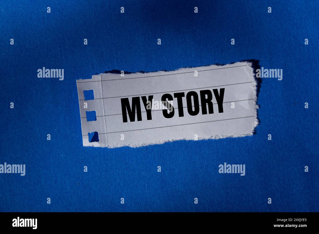My story message written on ripped torn paper piece with blue background. Conceptual my story ...
