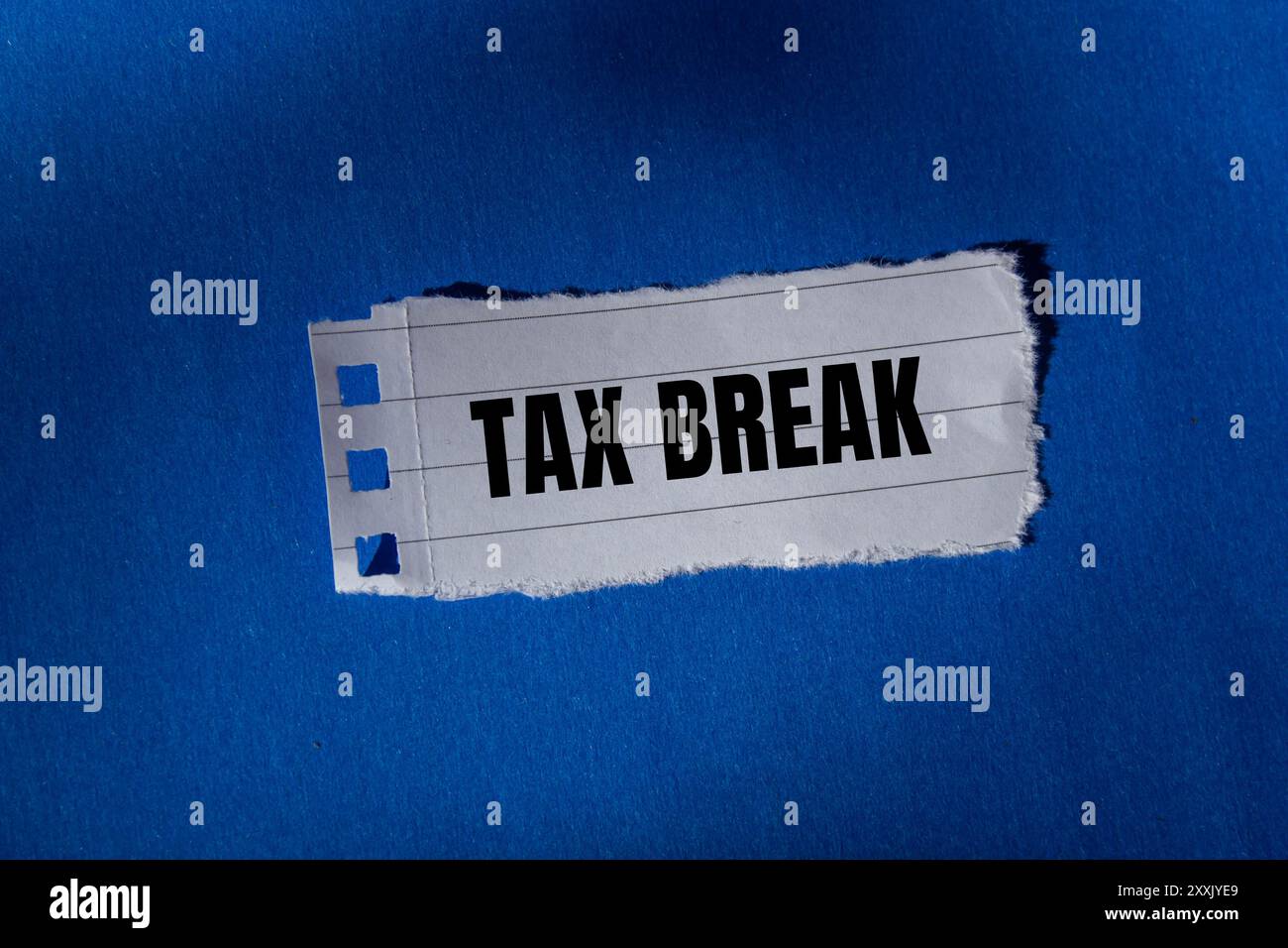 Tax break message written on ripped torn paper piece with blue ...