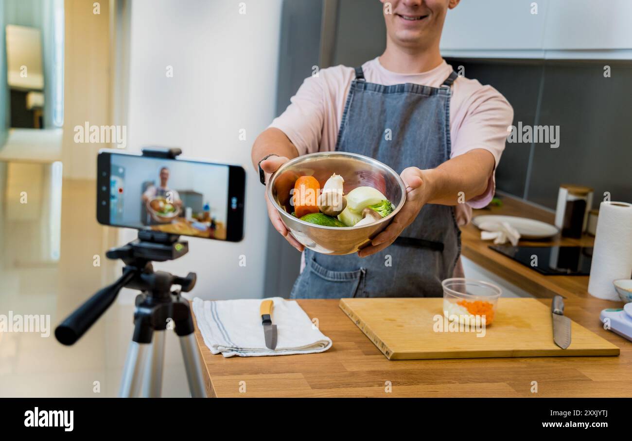 A man is exhibiting a vegan recipe in a live stream within a modern ...