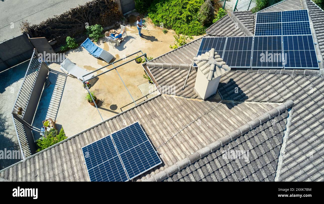An aerial view shows two women in a sunny backyard, one relaxing on a ...