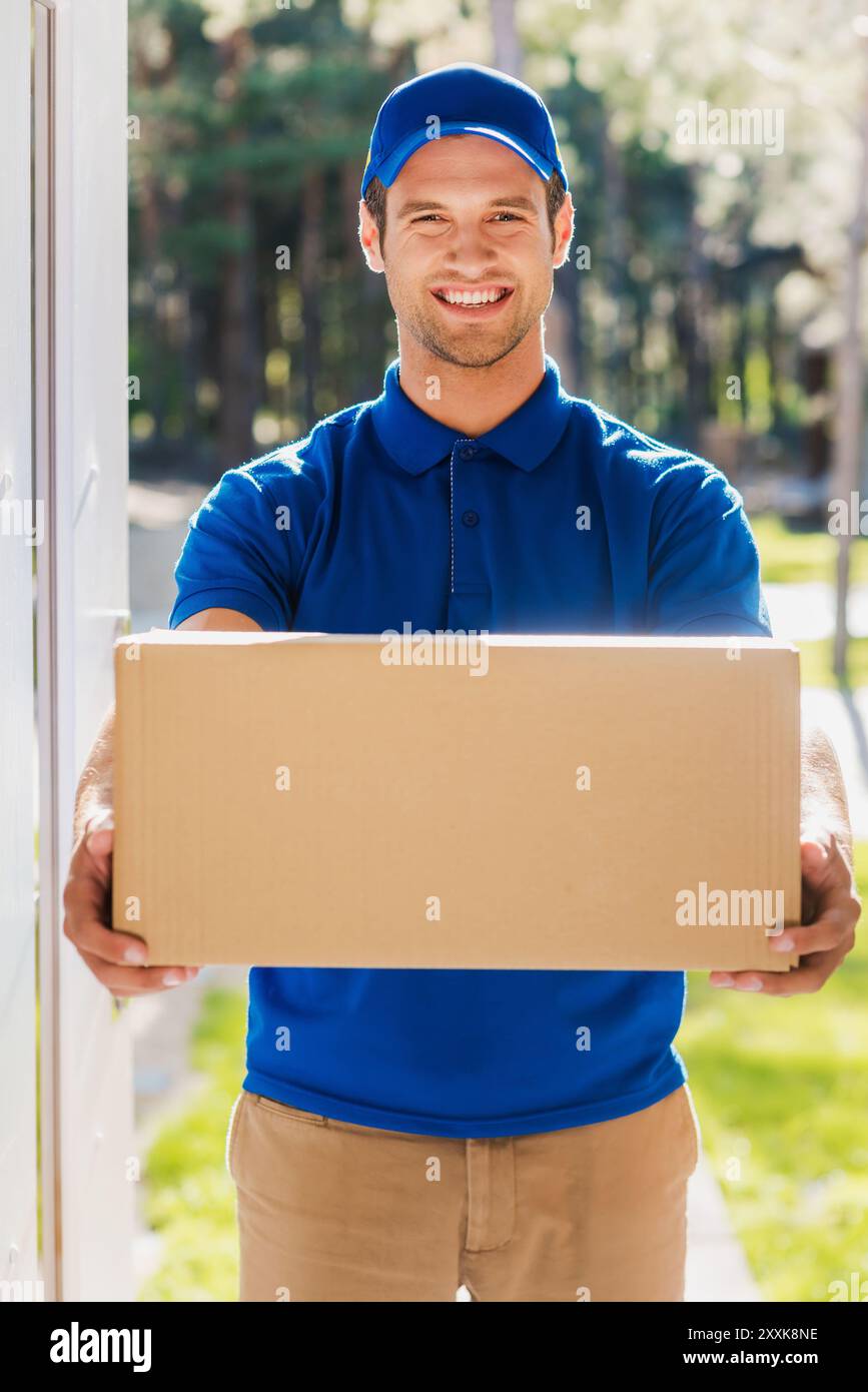 Smiling young delivery man arms hi-res stock photography and images - Alamy