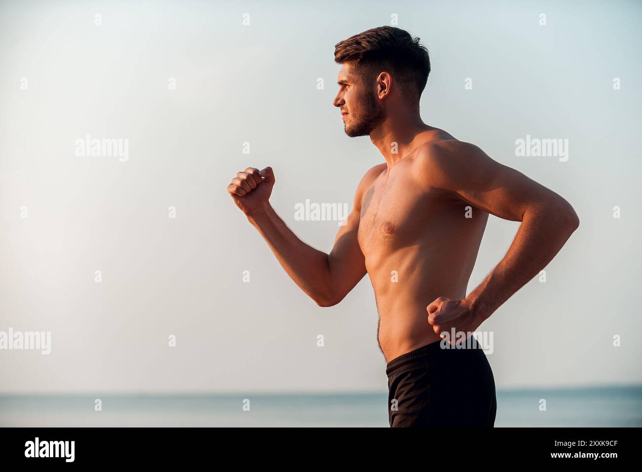 Energy inside him. Side view of confident young muscular man running ...