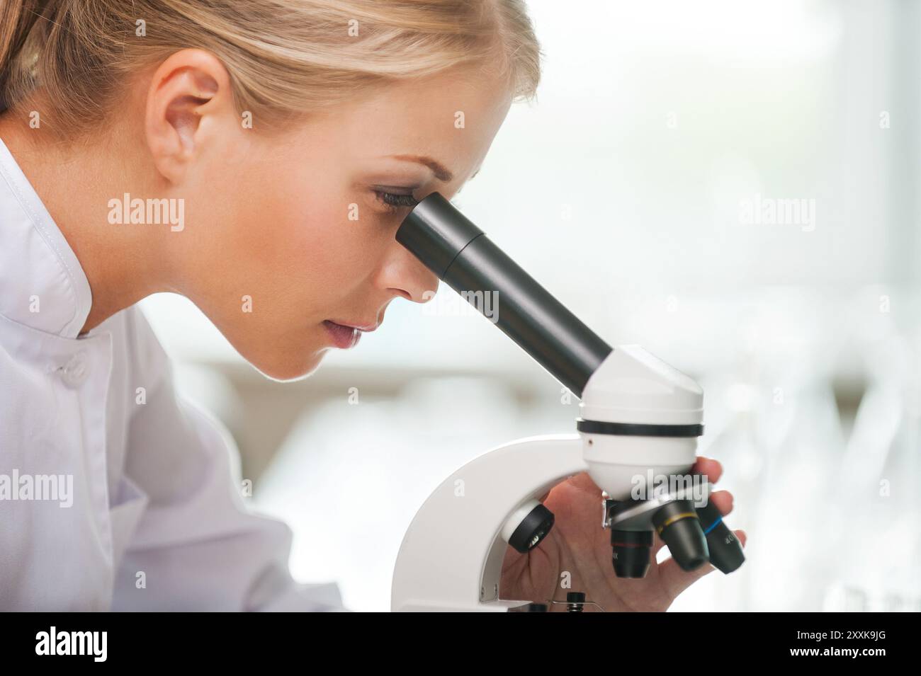 Taking closer look at bacteria. Side view of concentrated young female ...