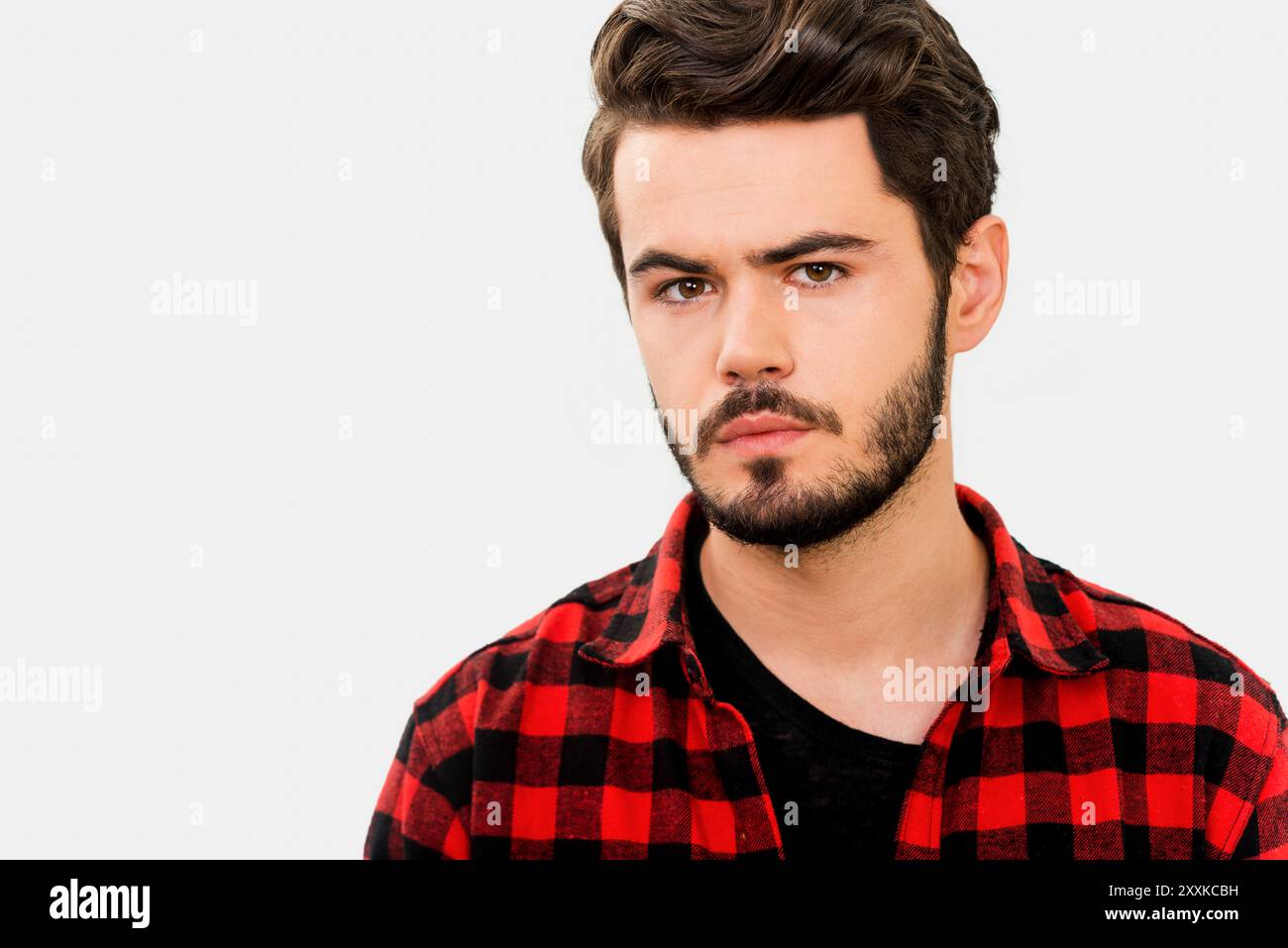 Suspicious glance. Serious young man looking at camera while standing ...