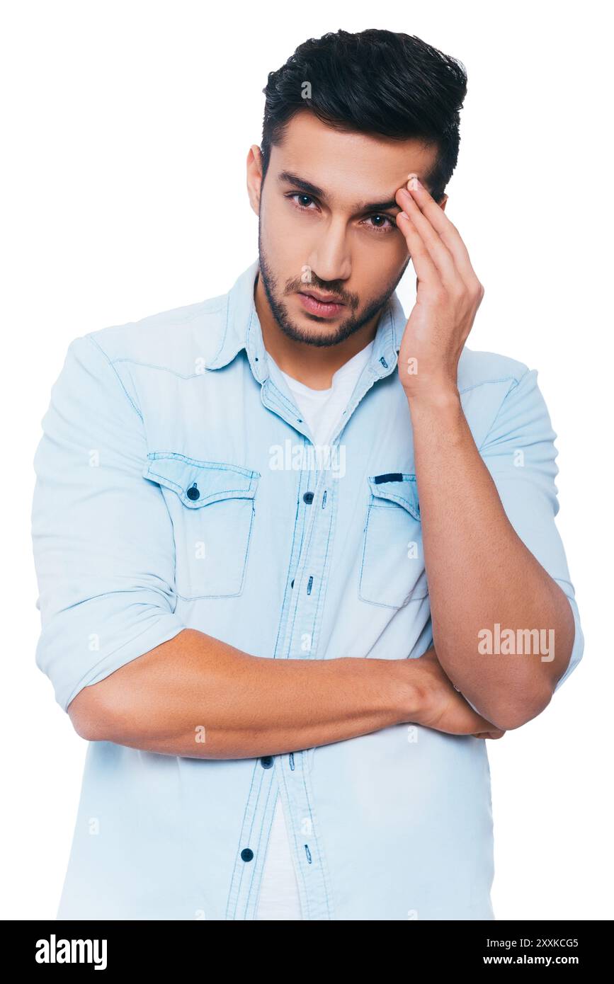 Thinking about solution. Thoughtful young Indian man touching head with ...