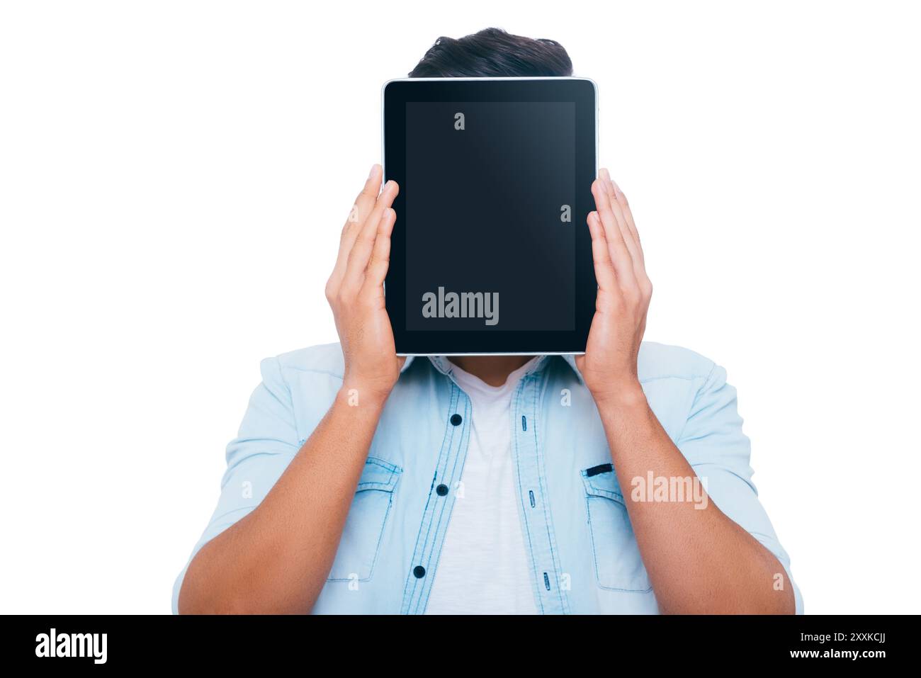 Tablet face. Young man hiding his face behind digital tablet while ...