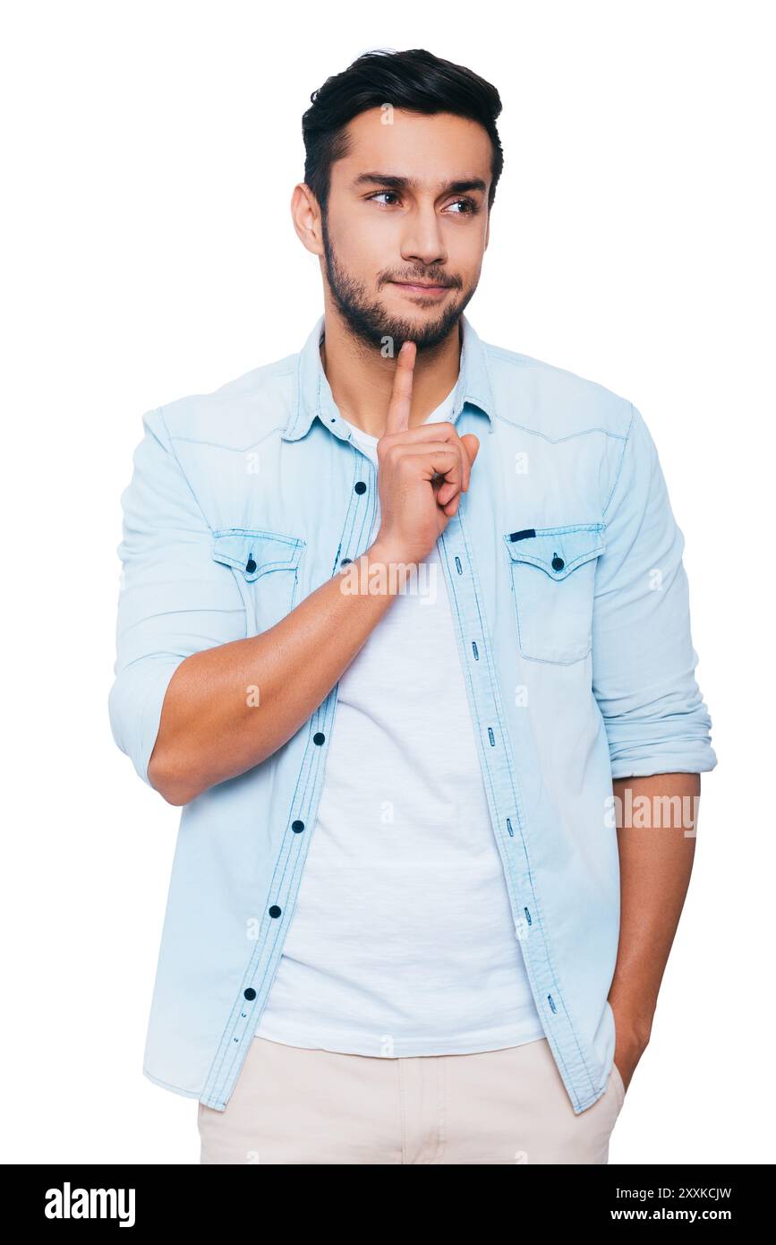 In search of solution. Thoughtful young Indian man touching his chin ...