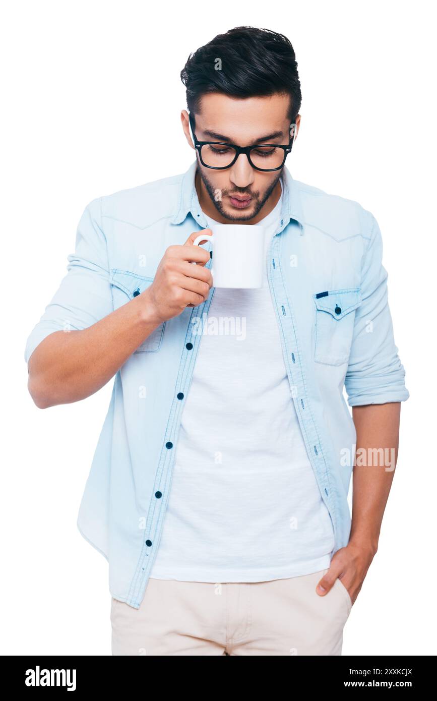 Too hot coffee. Handsome young Indian man holding cup with coffee and ...