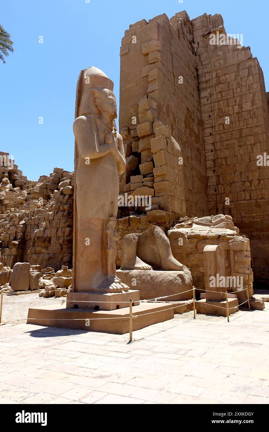 Visitors admire a towering statue at Karnak temple complex in Egypt ...