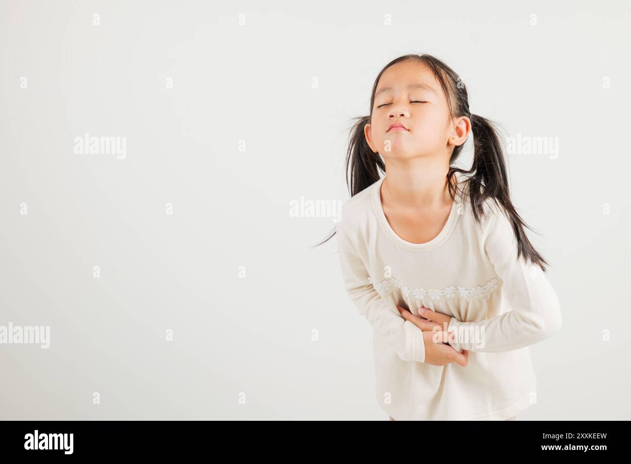 Portrait of Asian young kid girl has stomachache, kindergarten child ...