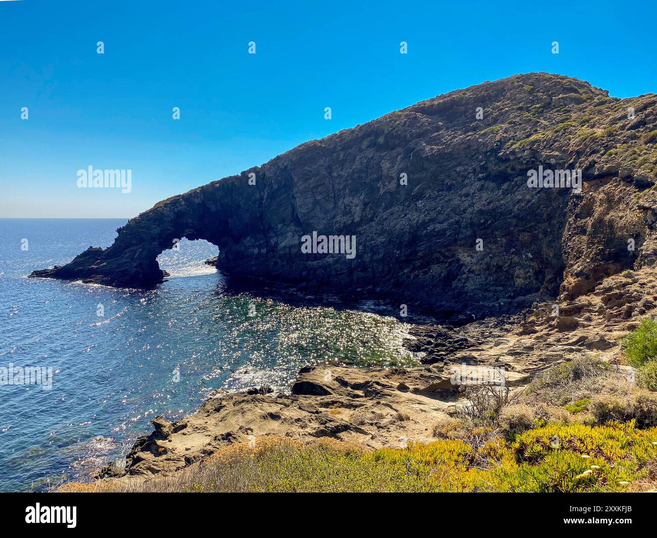 Elephant Arch huge lava rock cliff plunging into the water forming an ...