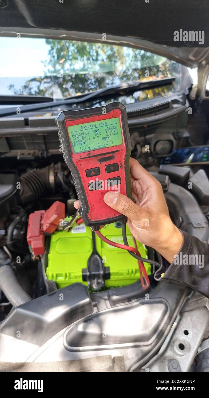Technician diagnosing newly installed battery health of automobile with ...