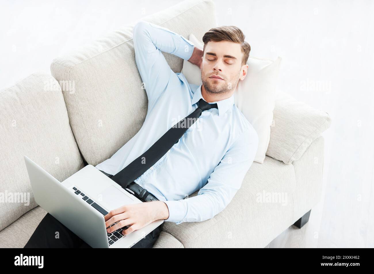 Work that makes him sleepy. Top view of young businessman sleeping and ...