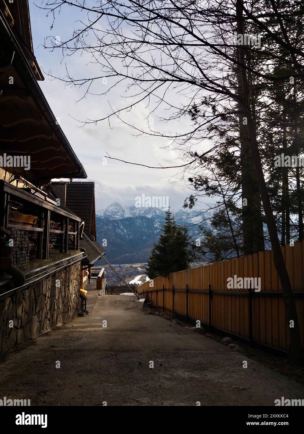 A narrow alleyway in a rustic mountain village leads to a stunning ...