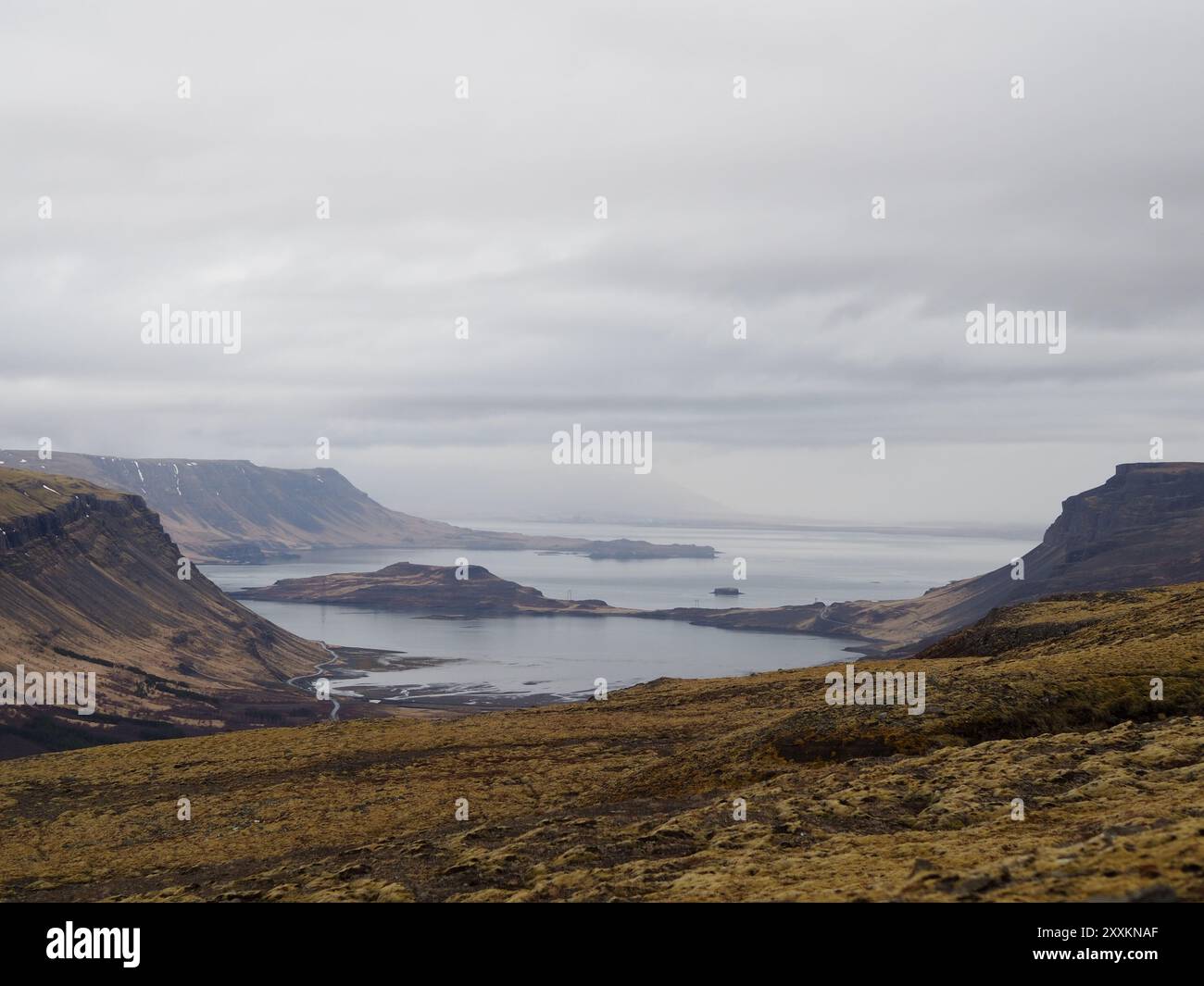 A vast landscape featuring a fjord stretching between rugged mountains ...