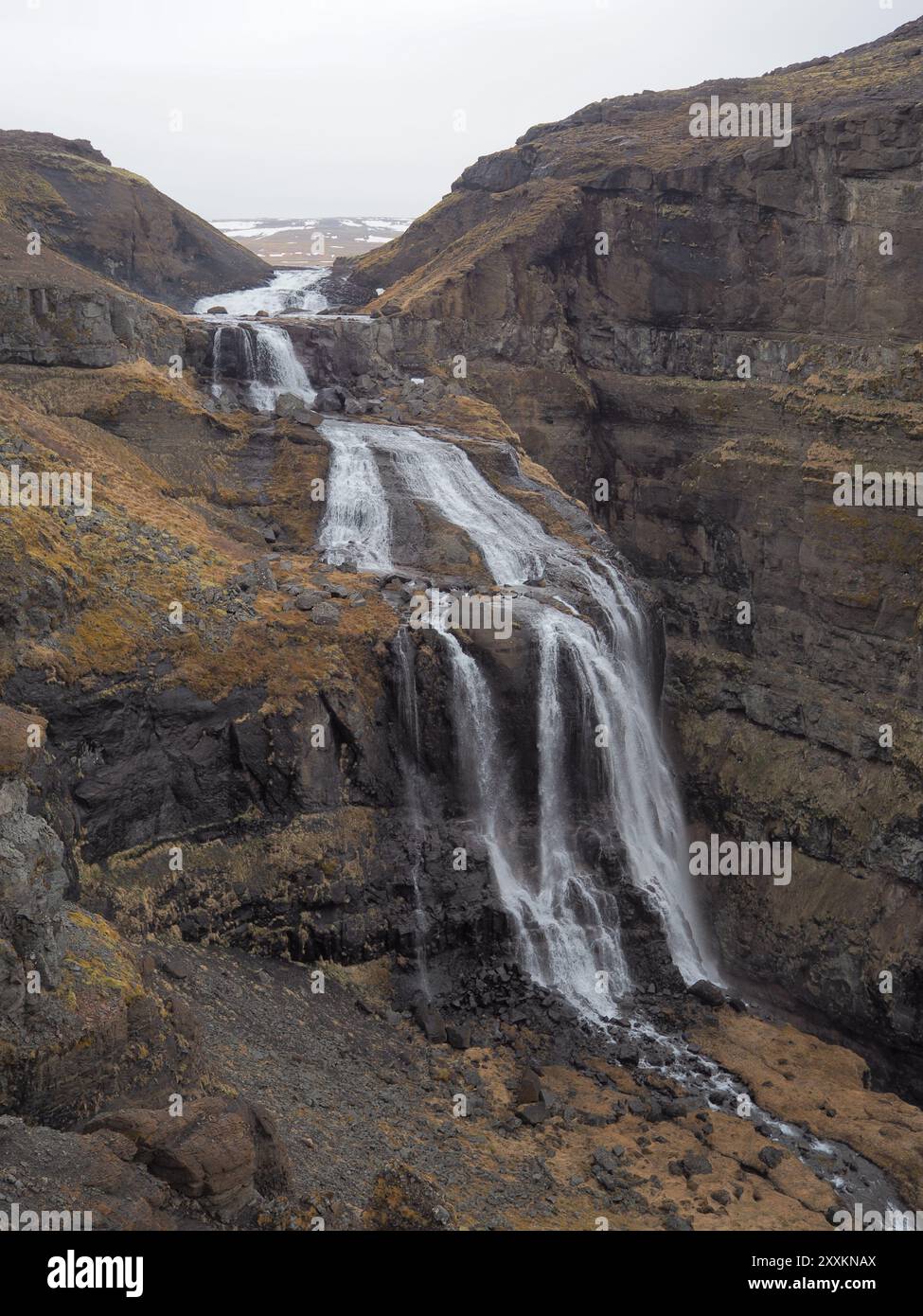 A majestic waterfall cascading impressively between steep rocky cliffs ...