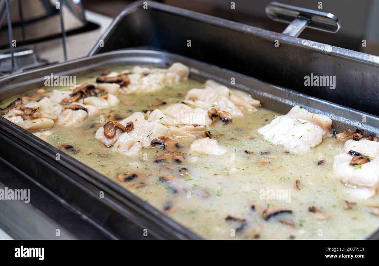 White fish with mushrooms in a metal container Stock Photo - Alamy