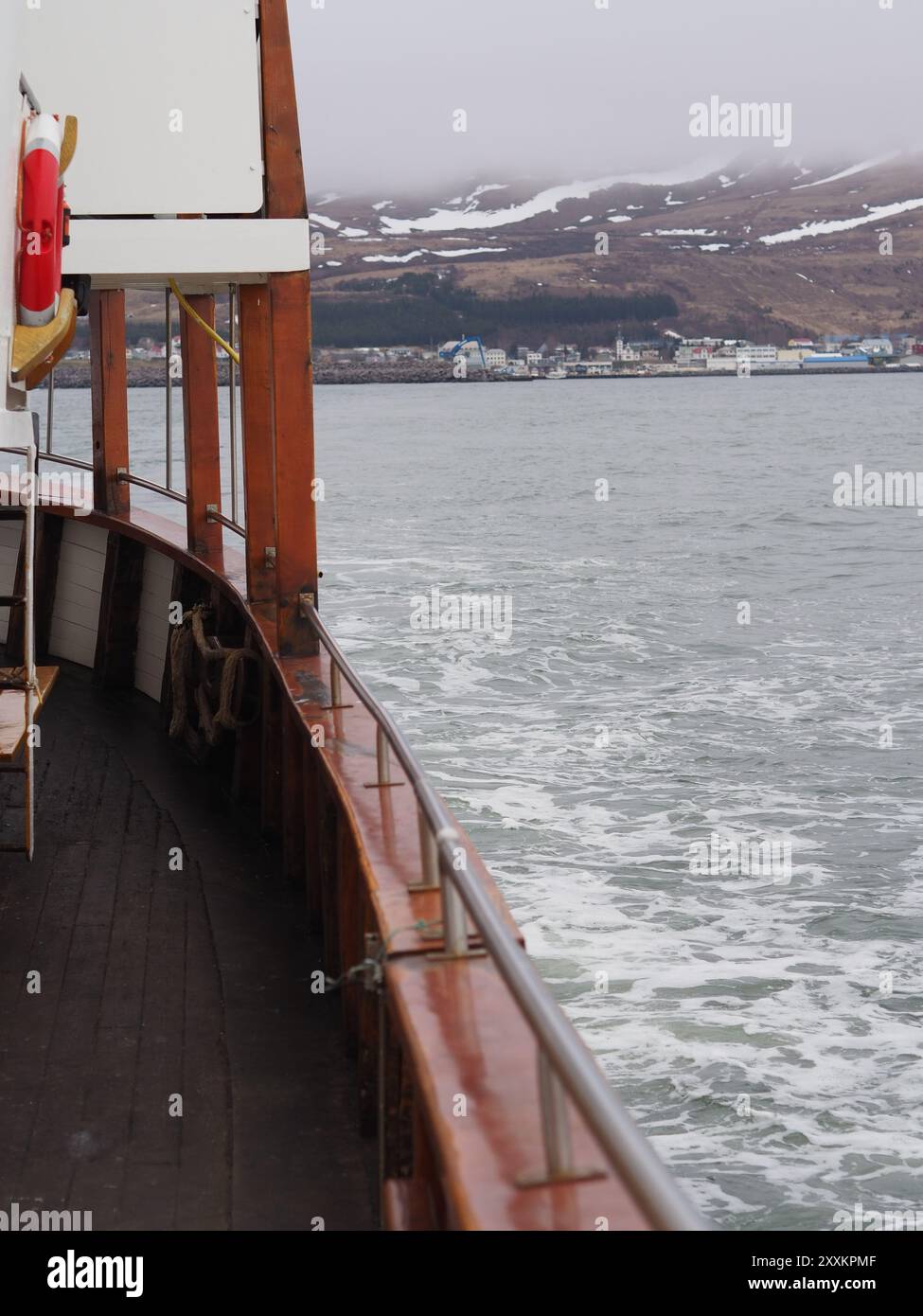 The wooden deck of a boat shows the wake trailing behind as it heads ...