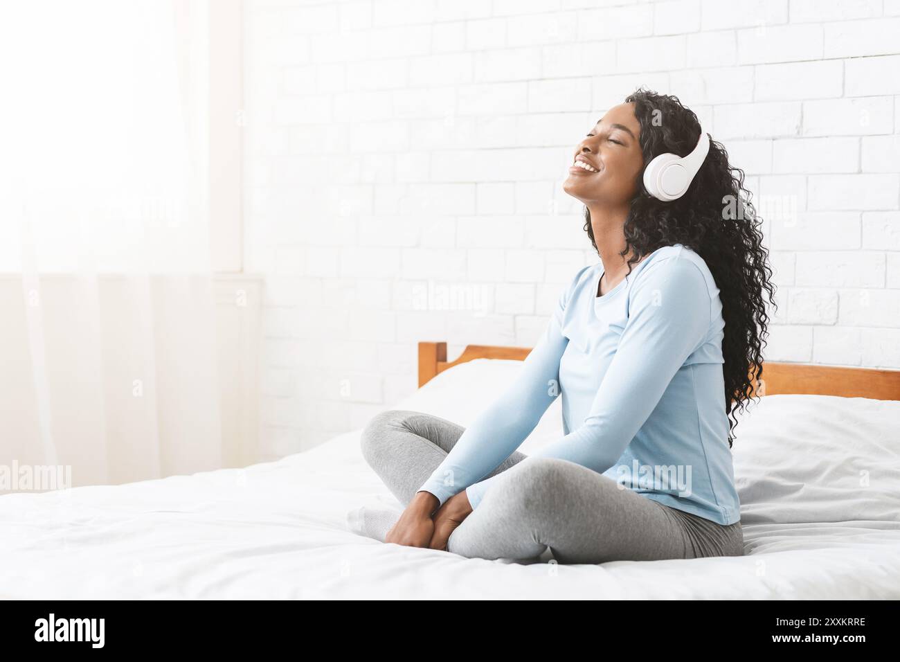 Joyful young girl listening to music in bedroom Stock Photo - Alamy