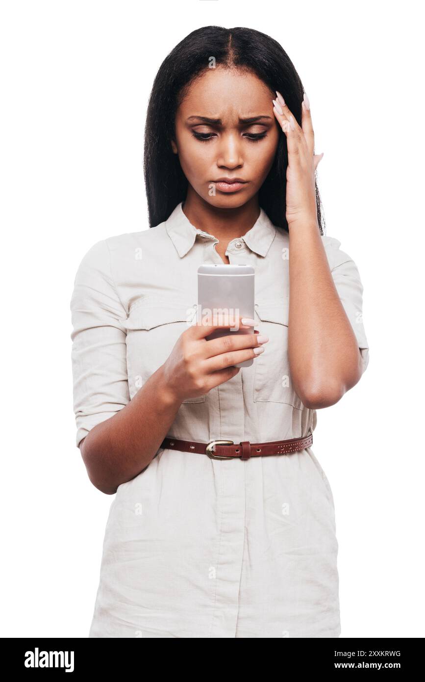 Bad news. Frustrated young African woman holding mobile phone and ...
