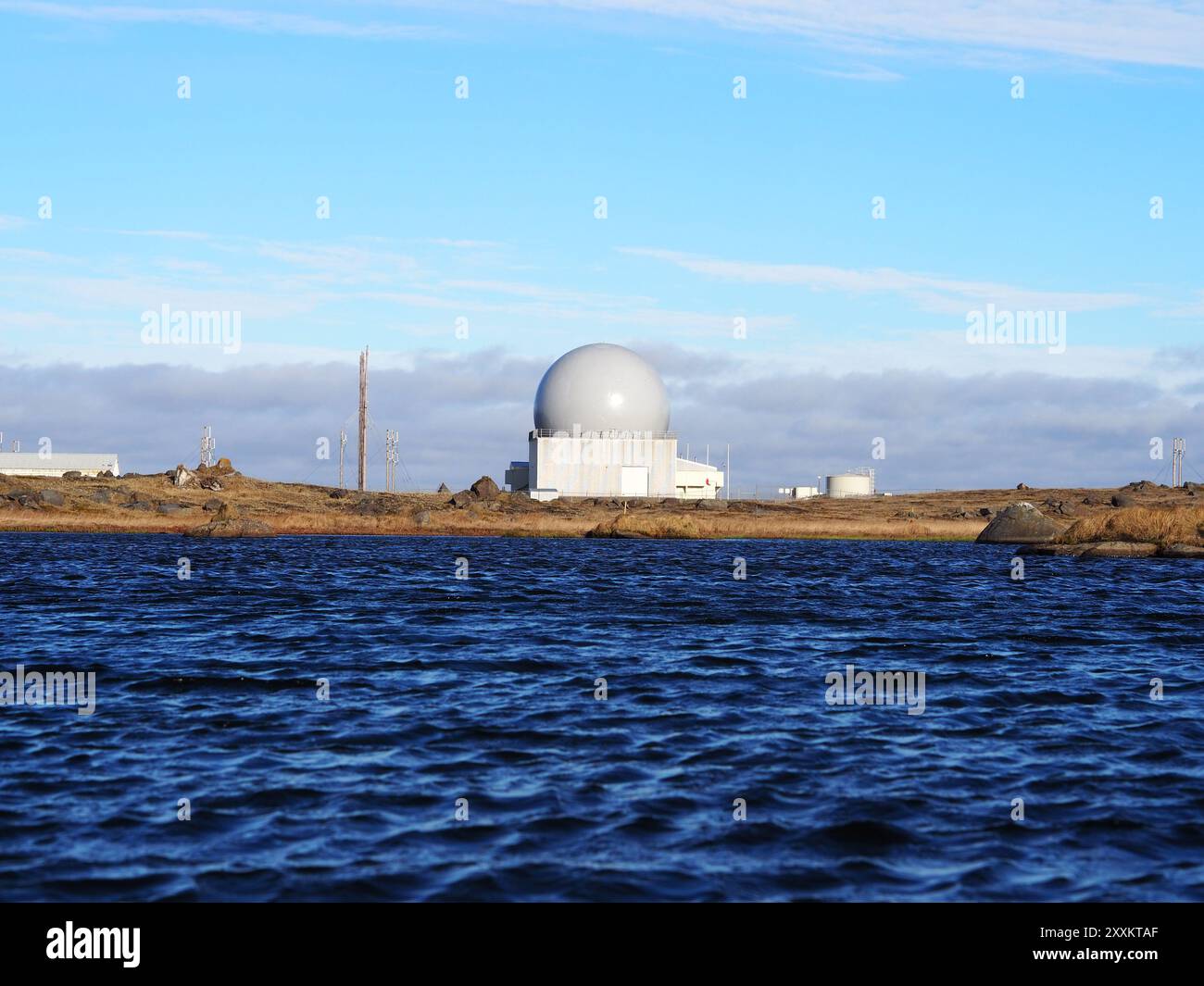 A large, distinctive geodesic dome structure stands near the water ...