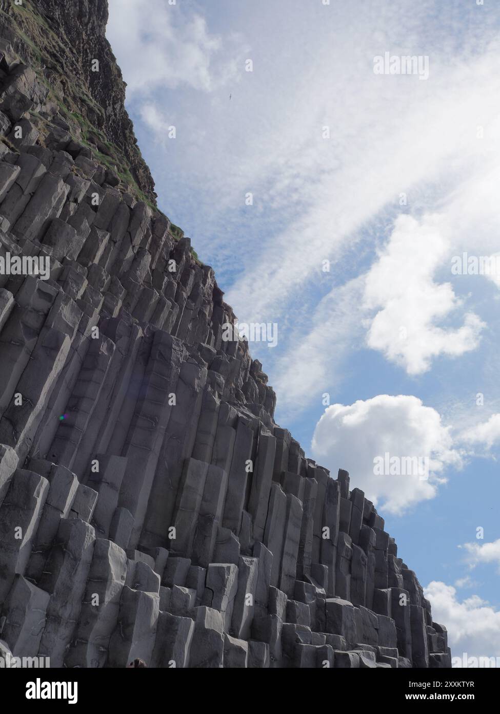 Stunning vertical columnar basalt formations extend against a bright ...