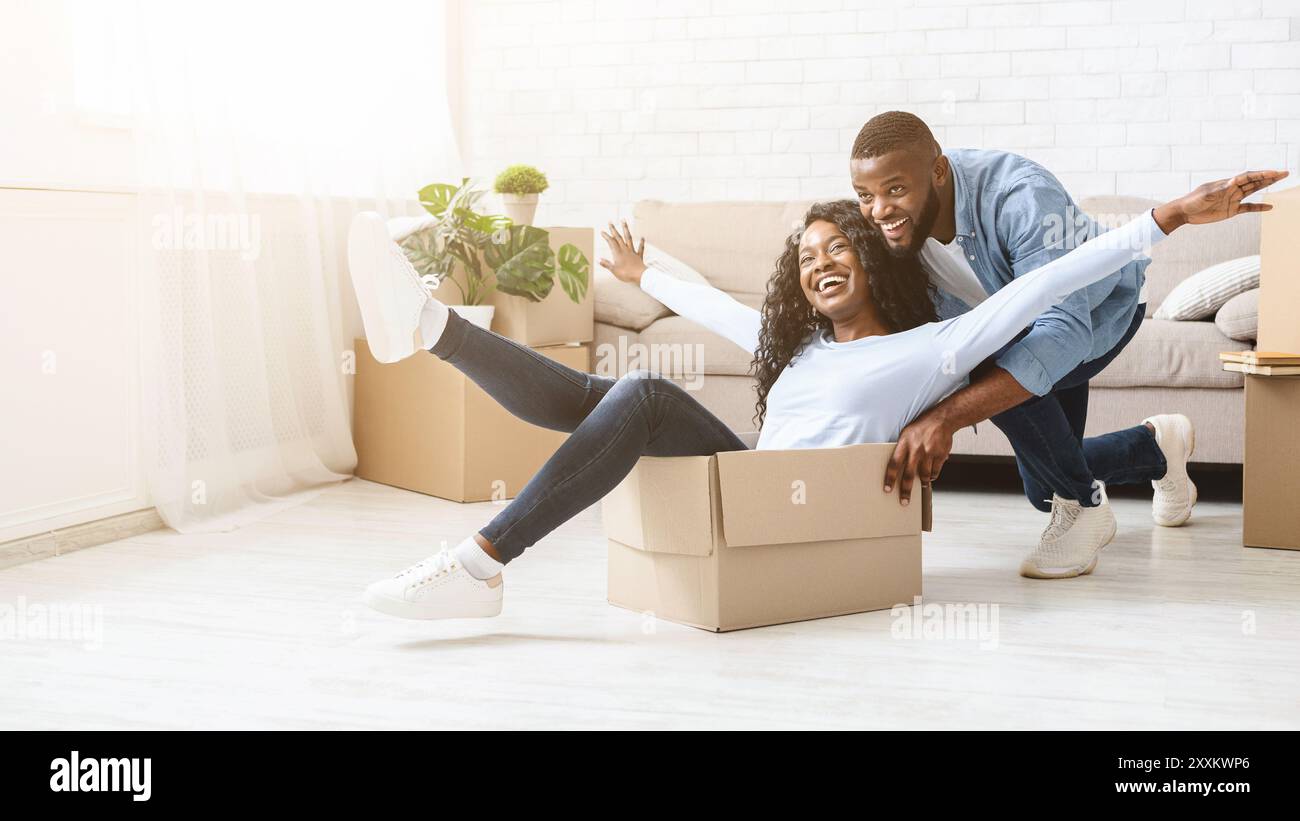 Young man pushing box with his woman, moving in Stock Photo - Alamy