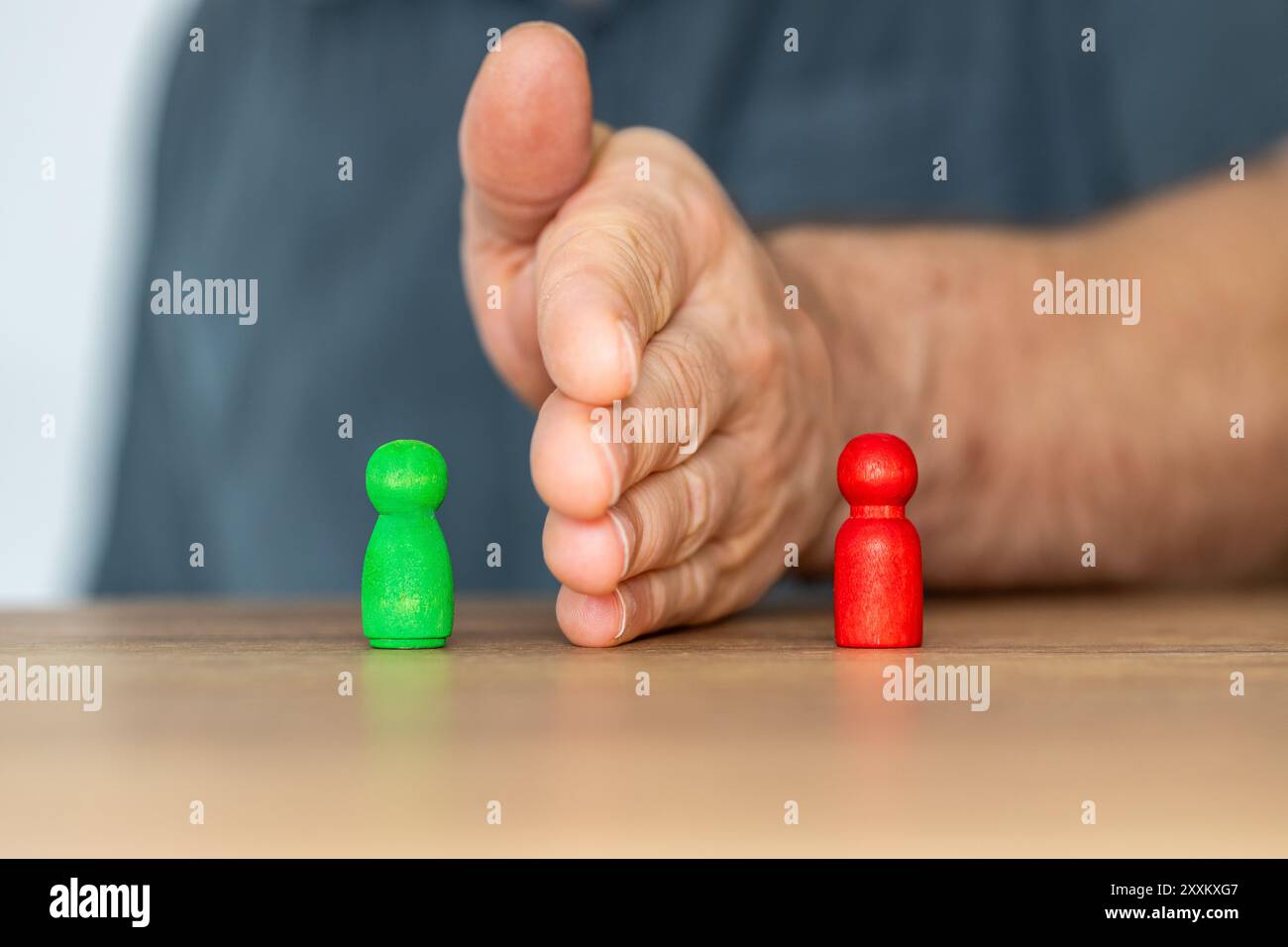 Person holds hand between two wooden figures. Soft skills and conflict ...