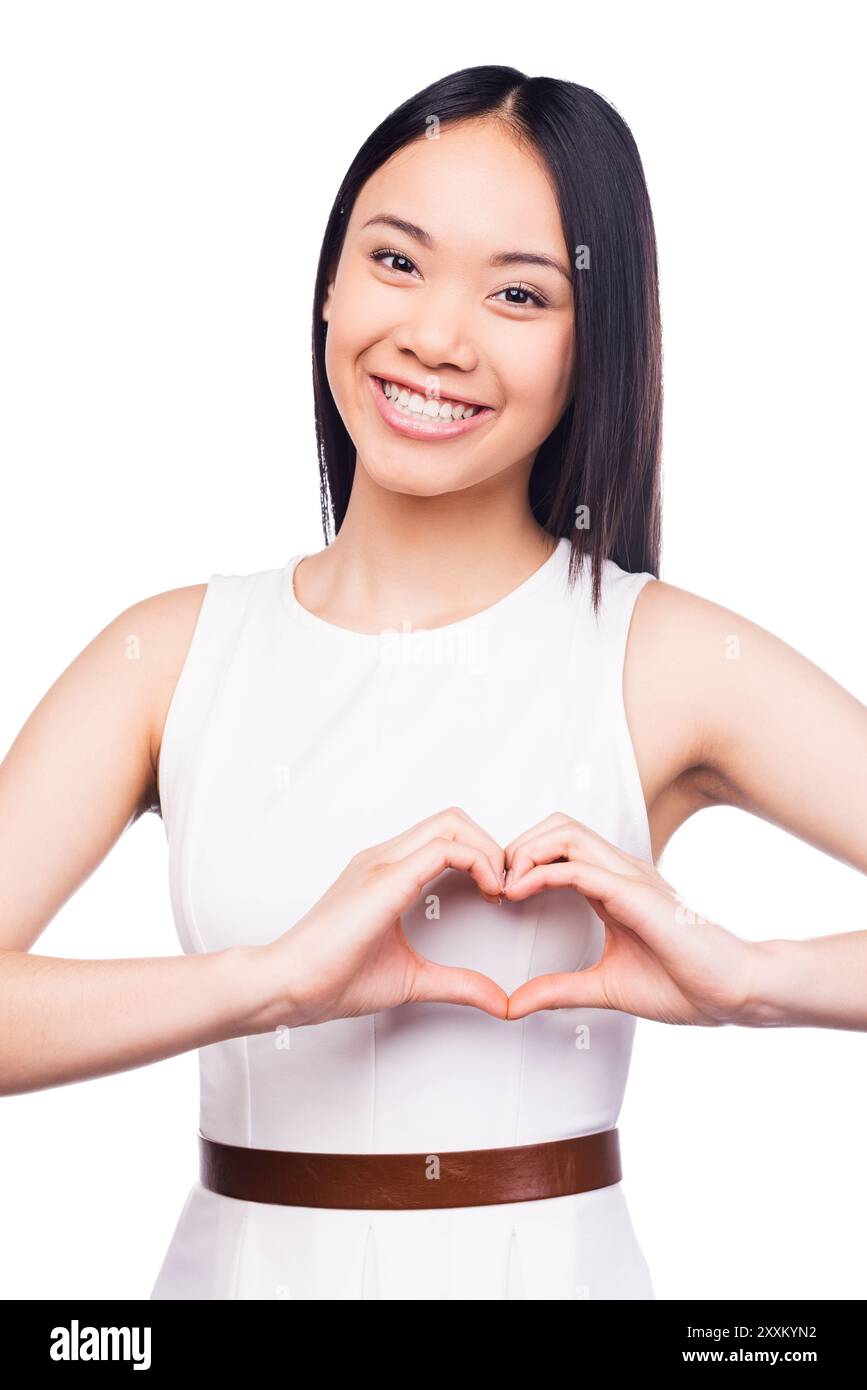 Gesturing finger heart. Beautiful young Asian woman looking at camera ...