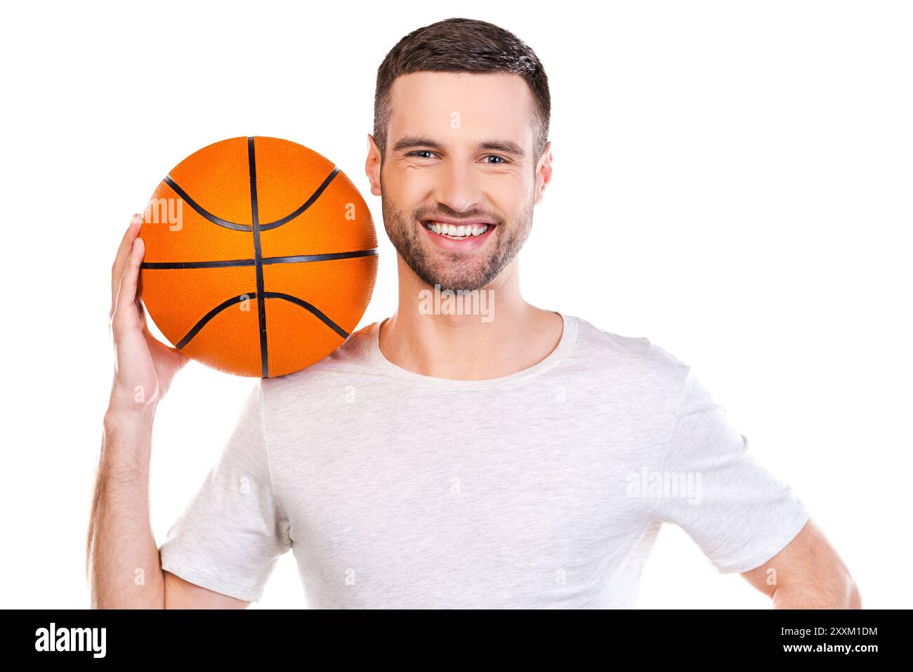 Ready to play. Confident young man carrying basketball ball on shoulder ...
