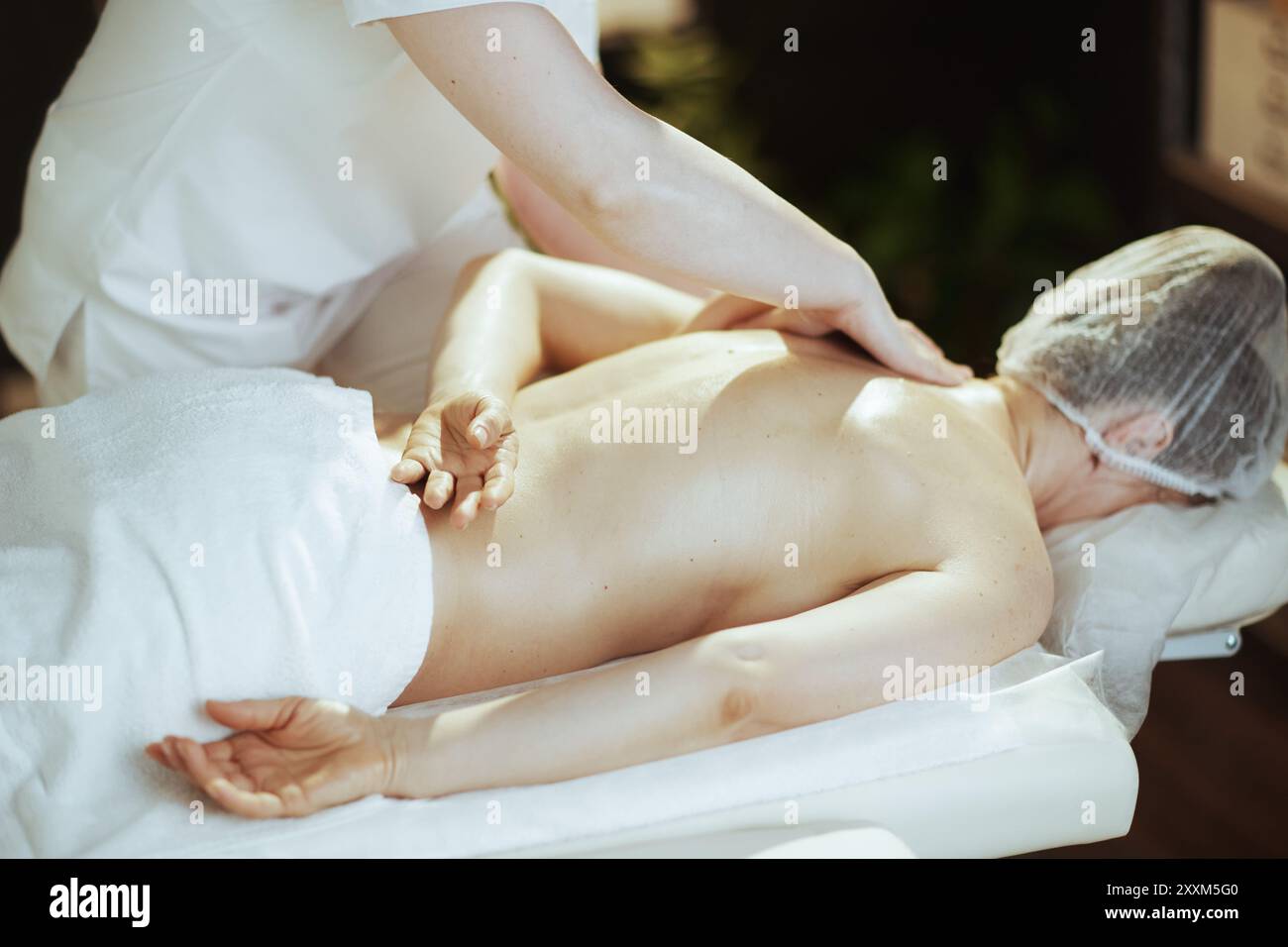 Healthcare time. medical massage therapist in spa salon massaging client on massage table Stock ...