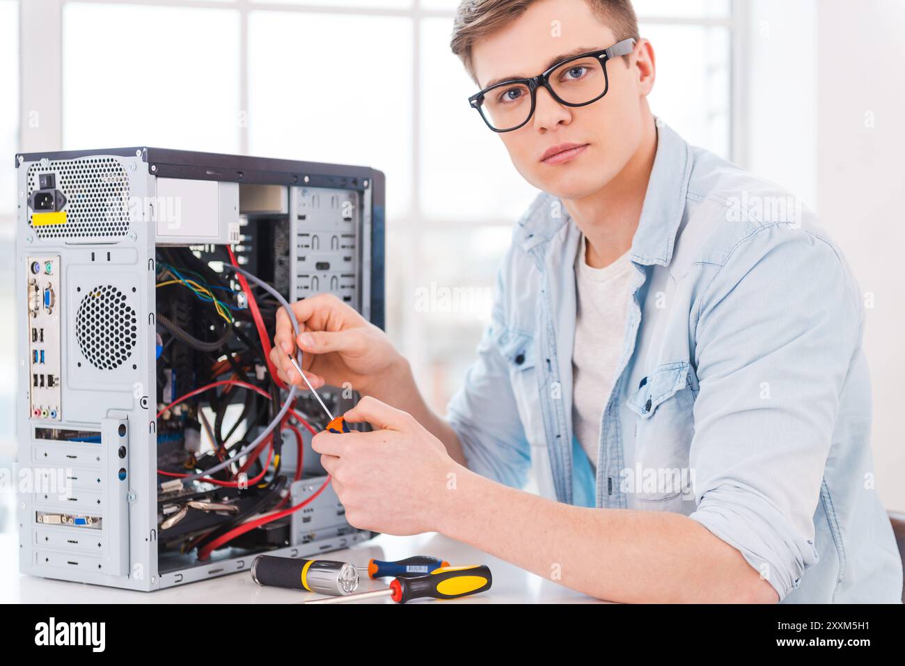 Smart professional. Portrait of handsome young man repairing computer ...