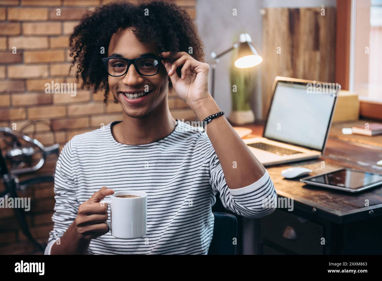 Coffee break. Cheerful young African man holding coffee cup and ...