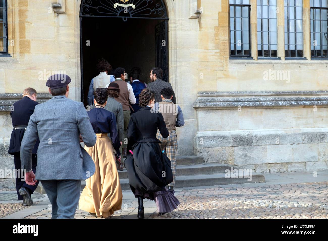 Rear view back behind of actors in historical costume men and women ...