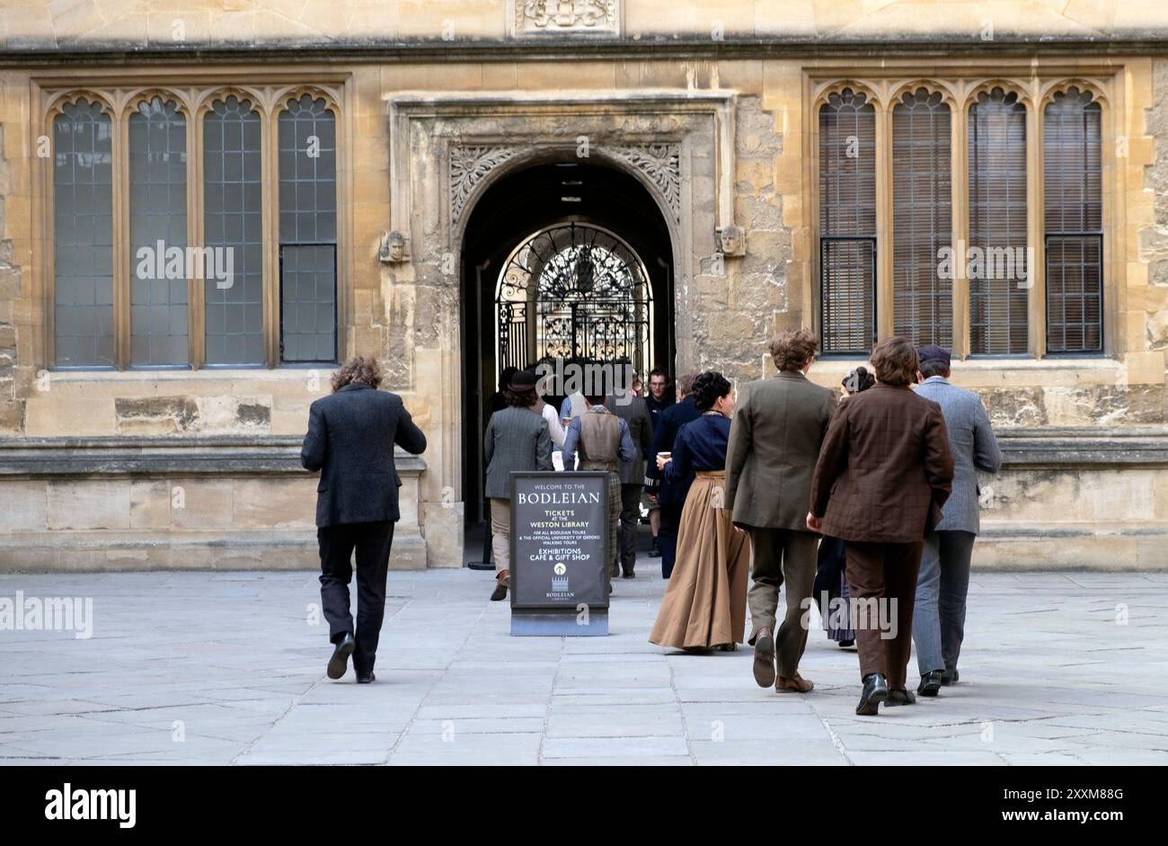 Rear view back behind of actors in historical costume men and women ...