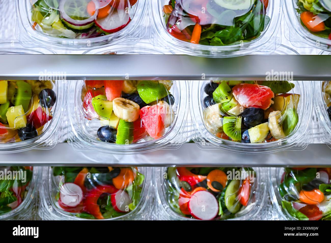 Plastic boxes with pre-packaged fruit and vegetable salads, put up for ...