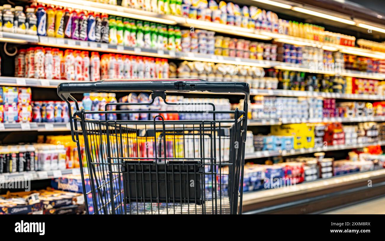 A shopping cart by a store shelf in a supermarket Stock Photo - Alamy