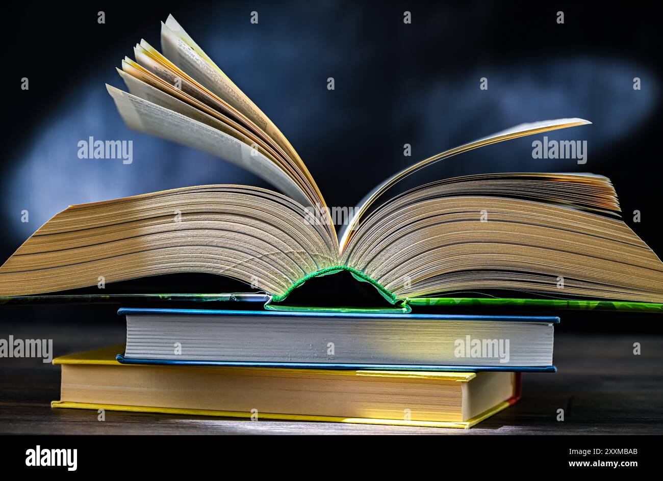 An open book lying on a stack of other books Stock Photo - Alamy