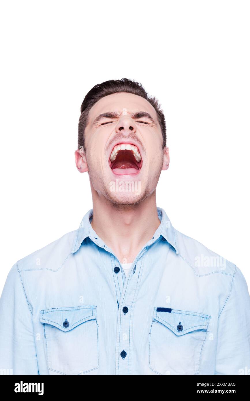 Cry of despair. Handsome young man shouting while standing against ...