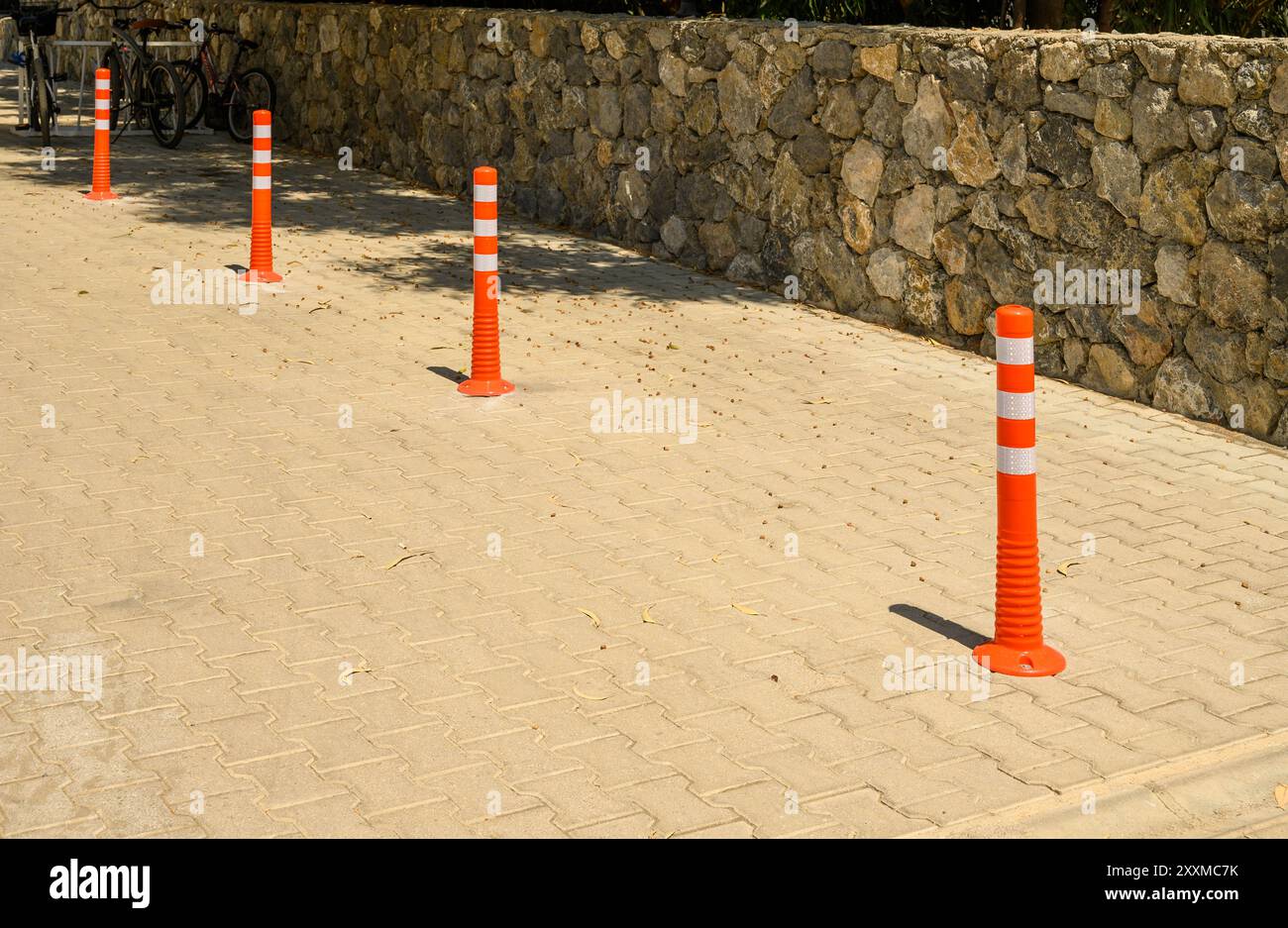 Sidewalk anti-parking bollards with reflective tape in the parking lot ...