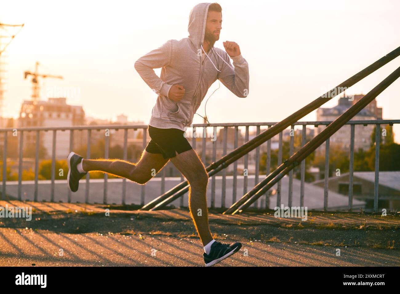 Moving to his goal. Side view of confident young man running along the ...