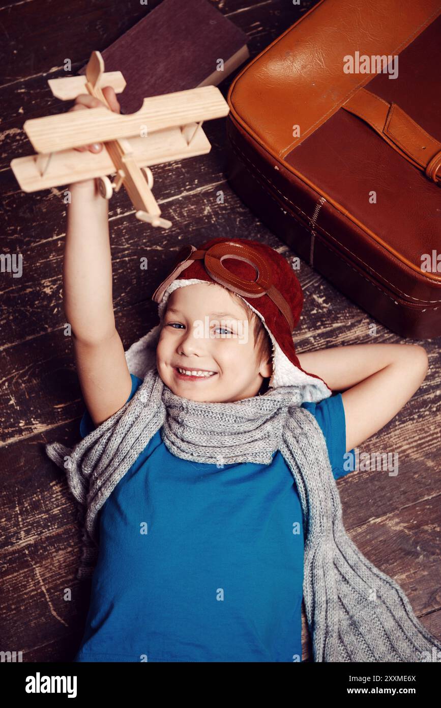 Little day dreamer. Top view of happy little boy in pilot headwear and ...